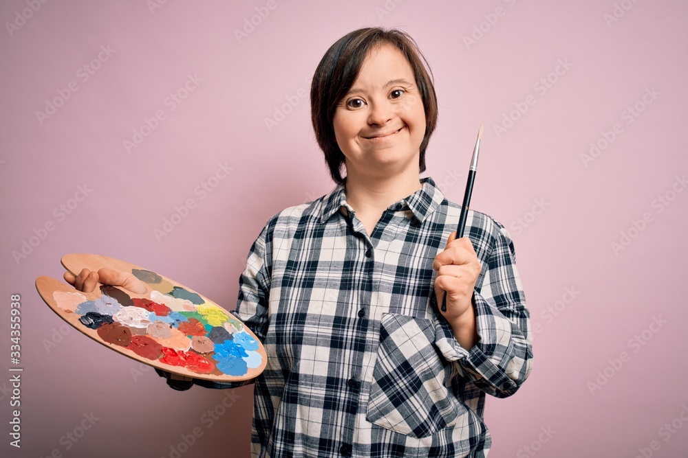 Young down syndrome artist woman holding painter palette and paintbrush ...