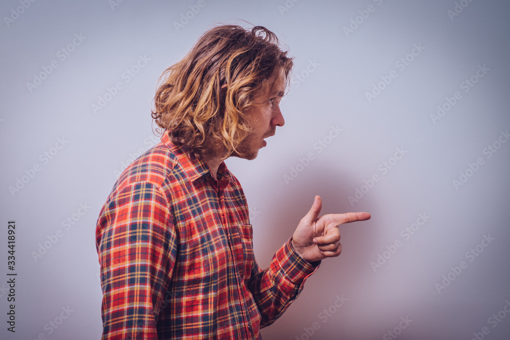 Closeup side view portrait of young man, pointing with finger at ...
