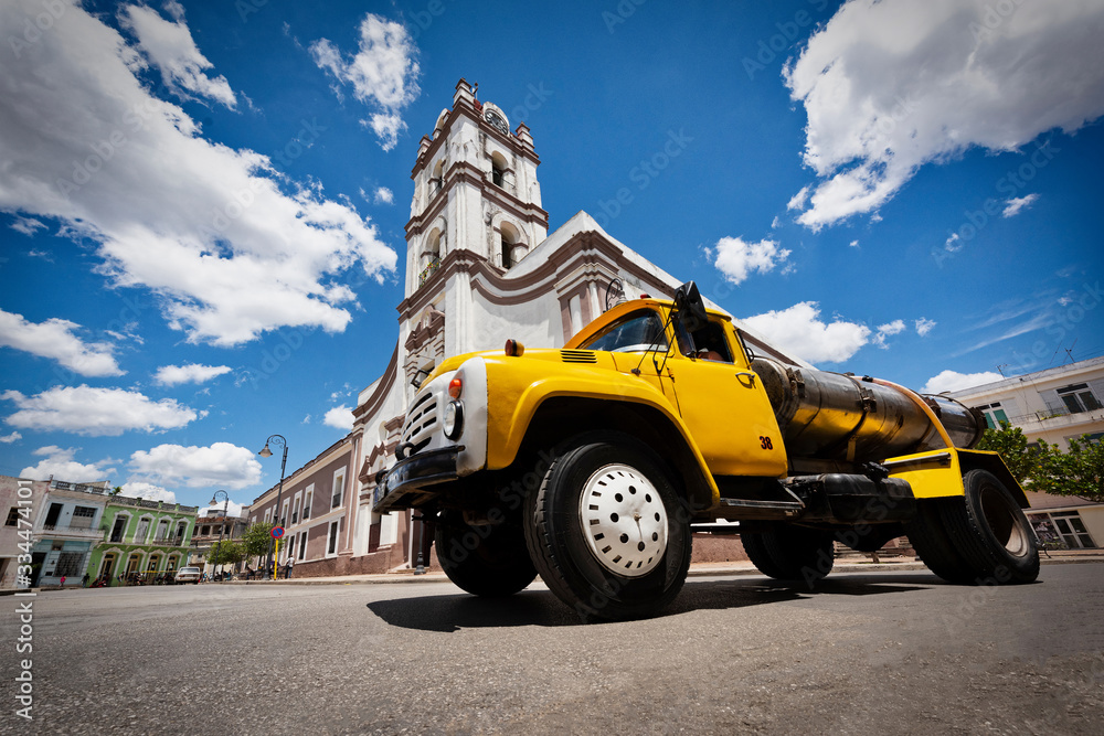 Yellow truck next to the Cathedral of Our Lady of Candelaria.Cuban is ...