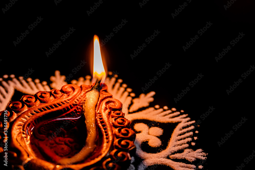 beautiful earthen oil lamp glowing white rangoli and dark background ...