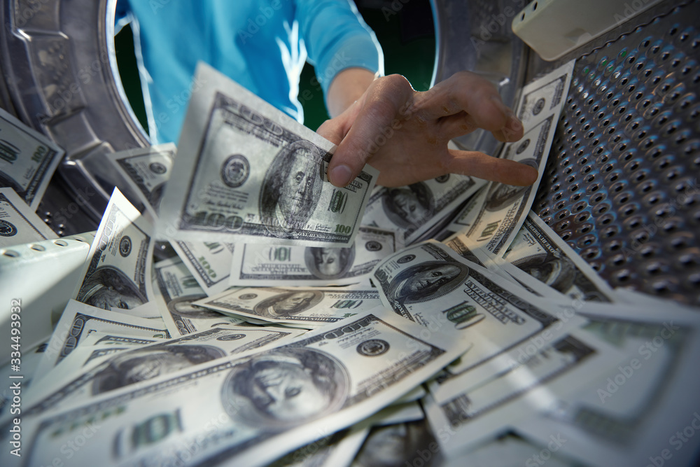Criminal washing banknotes in machine, money laundering, financial ...