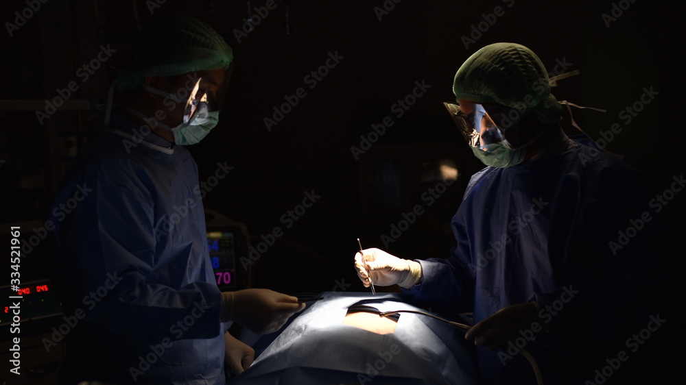 surgical instrument lying on table while group of surgeon work in ...