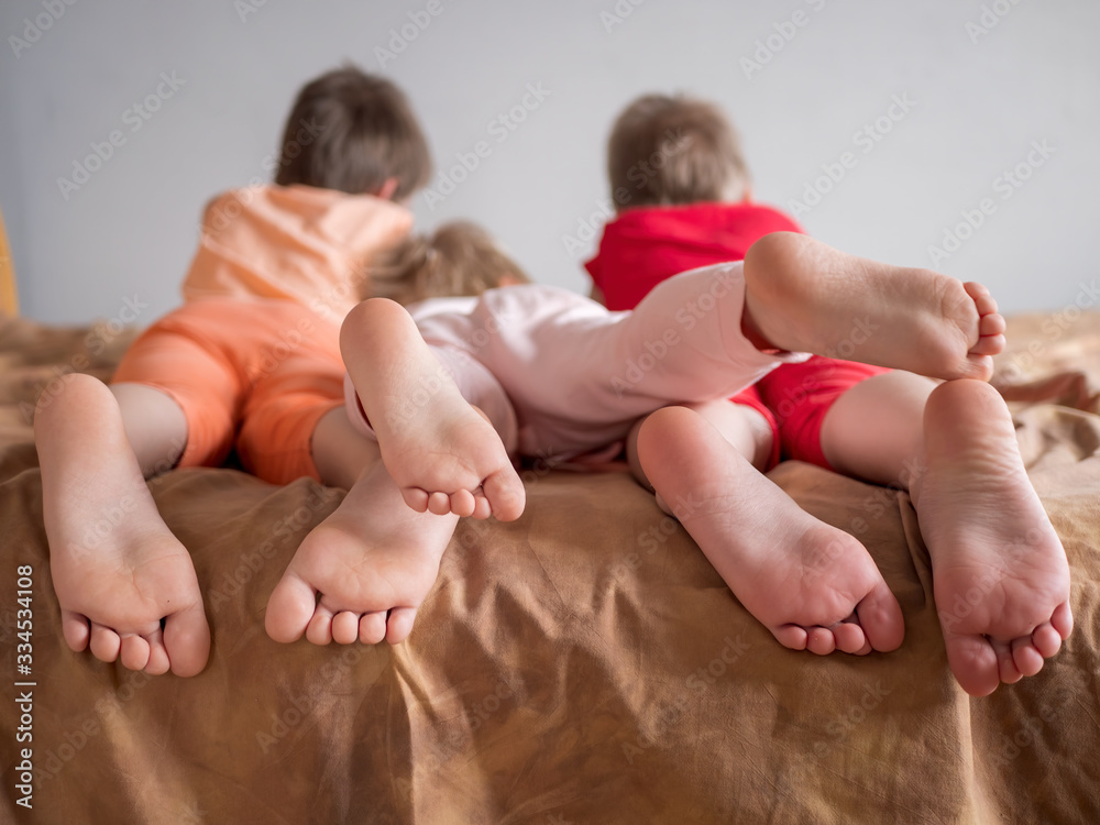 Three brother boys were lying on couch and were busy with phone and ...