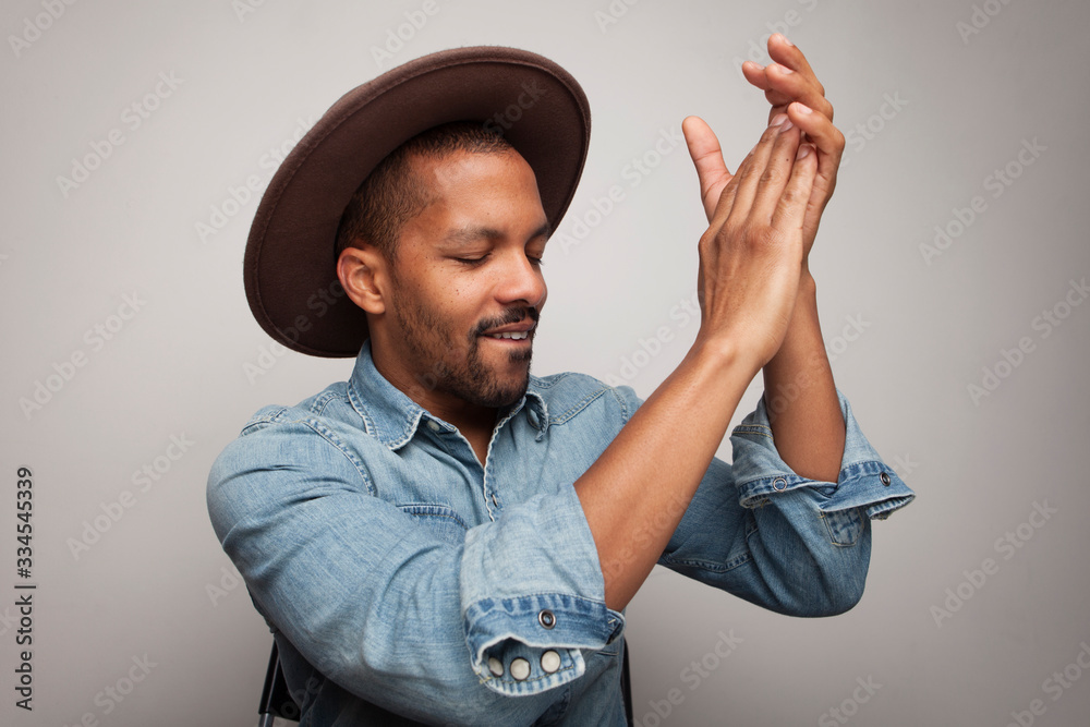 Young black man feeling happy and successful, smiling and clapping ...
