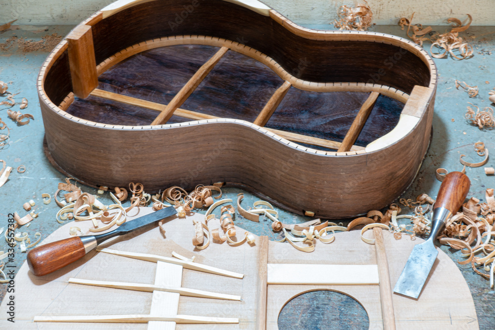 Luthier workbench with tools and an acoustic guitar under construction ...