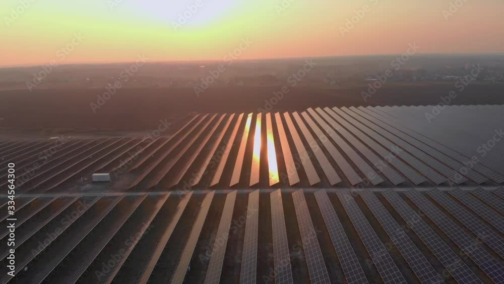 Aerial drone view into large solar panels at a solar farm at bright ...