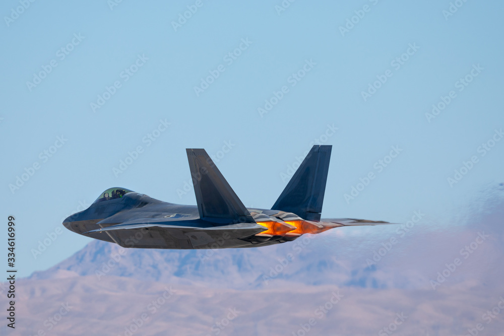 Very low pass of a F-22 Raptor against the Nevada hills, with ...