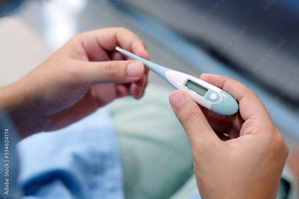 Closeup of man looking at thermometer, Male hand holding a digital ...