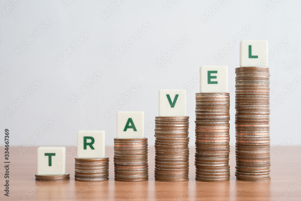 Word TRAVEL on step stacked coins as graph up with white background ...
