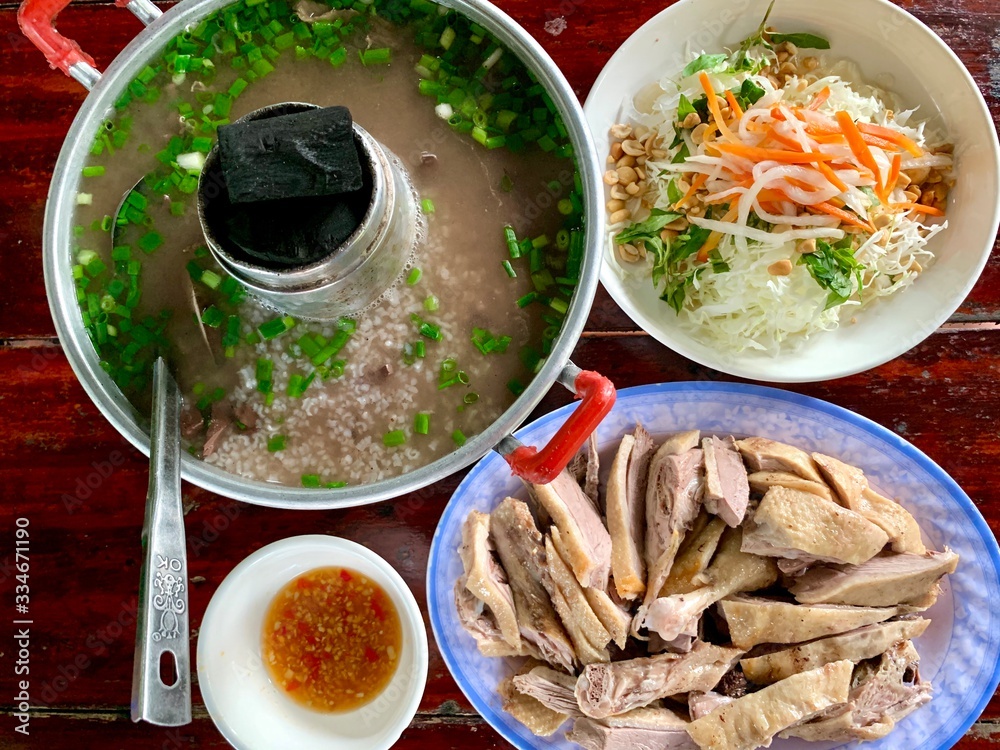 Vietnamese traditional duck meat rice soup hot pot with salad and fish ...