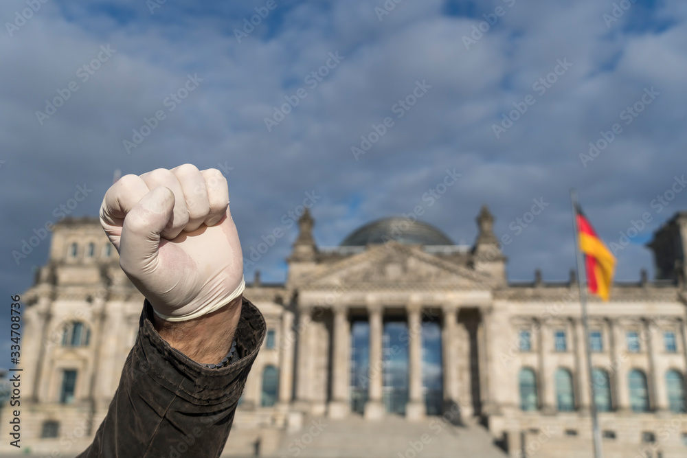Hand with latex glove showing the raised left hand fist to the German ...