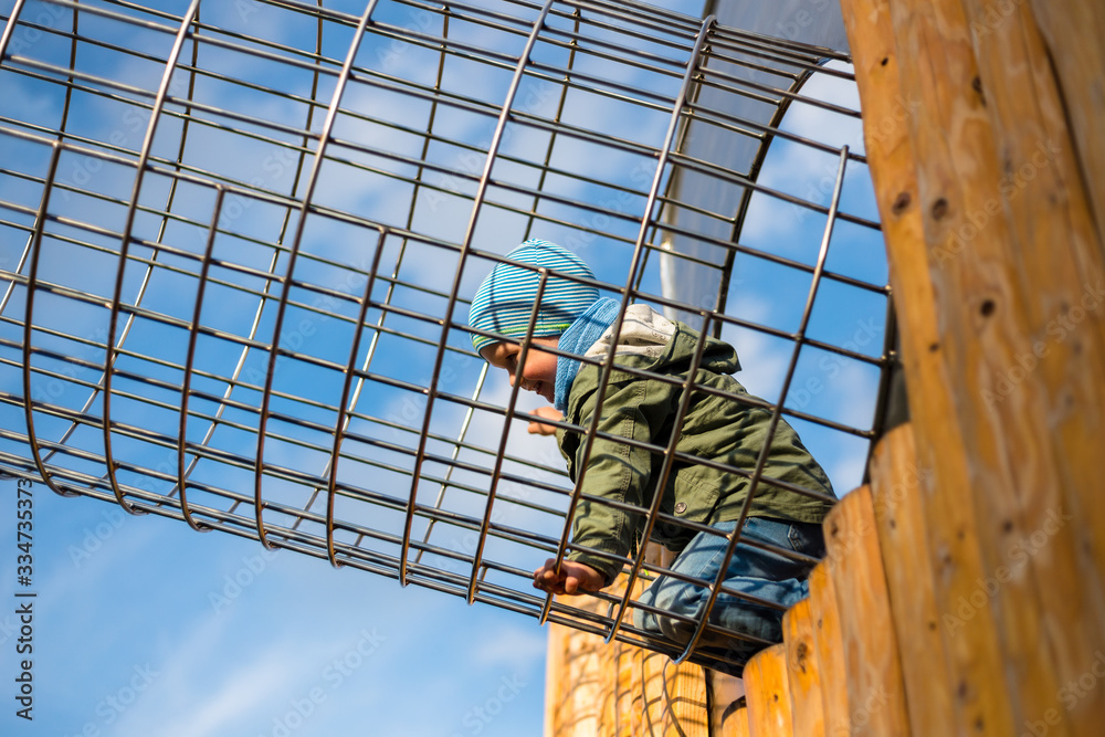 Little boy walking on a metal grid on the playground Stock Photo ...