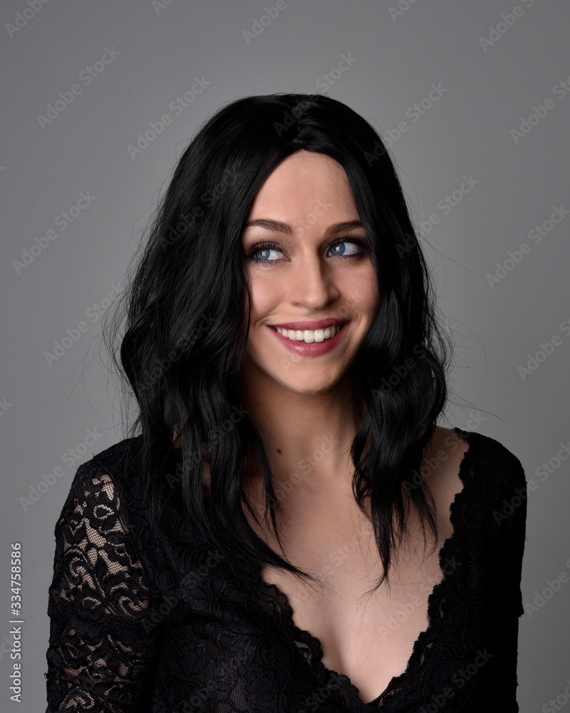 Close up portrait of a pretty, goth girl with dark hair posing in front ...