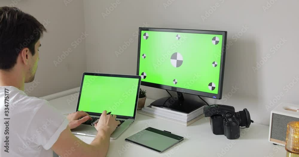 Handsome freelancer man photographer looking at laptop, typing on ...