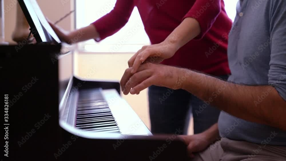 Detail of teacher explaining correct hands position of piano keyboard ...