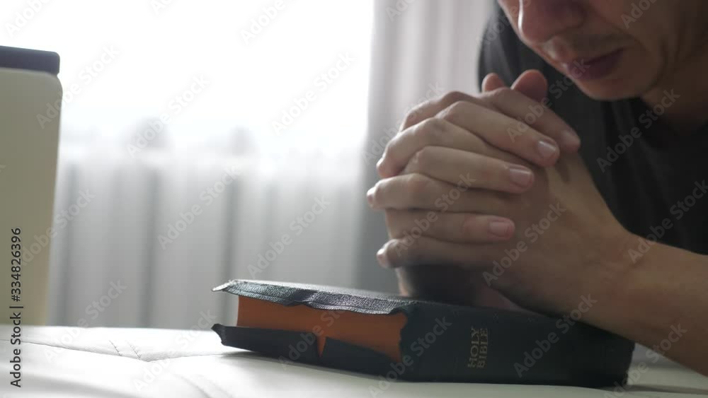 man praying indoors at bedtime on bible. lifestyle religion concept ...