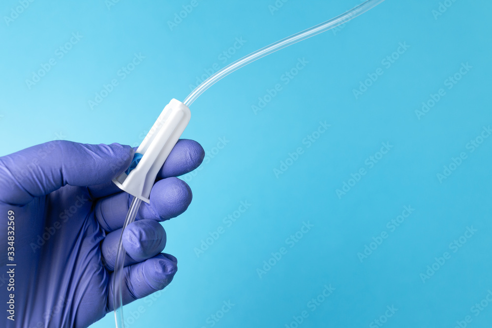 Nurse regulating infusion system by using a roller clamp. Blue ...