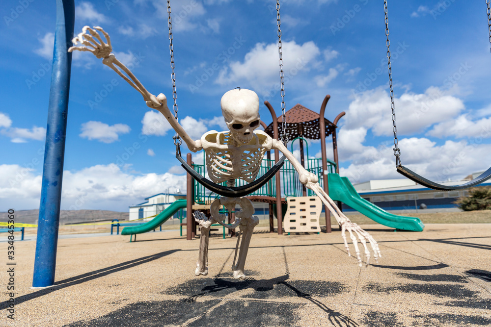 Skeleton playing superman on a child's swing in an empty park Stock ...