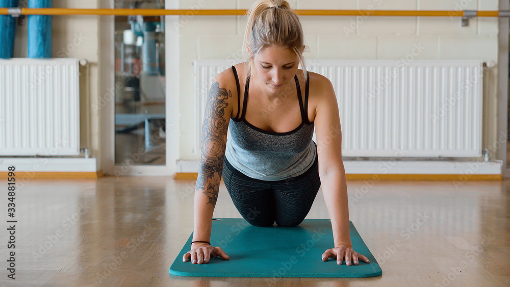 Young girl doing push ups at a gym - lifestyle photography Stock Photo ...
