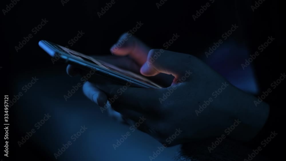 Young woman browsing internet on smart phone at night; girls finger ...