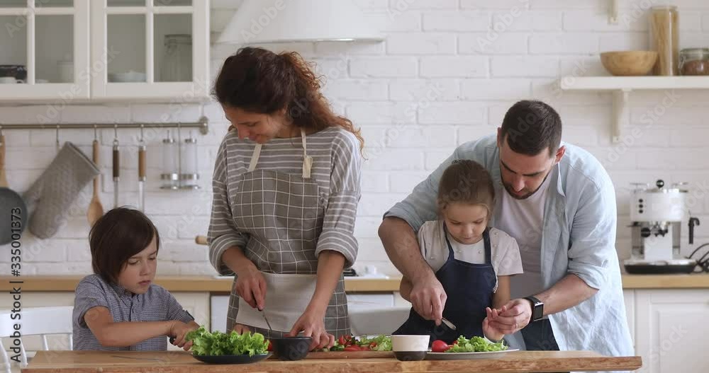 Happy family mom dad and kids siblings cooking together, young parents ...