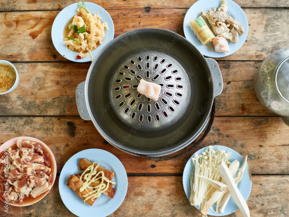 A Mookata pot is being warmed up. Stock Photo | Adobe Stock