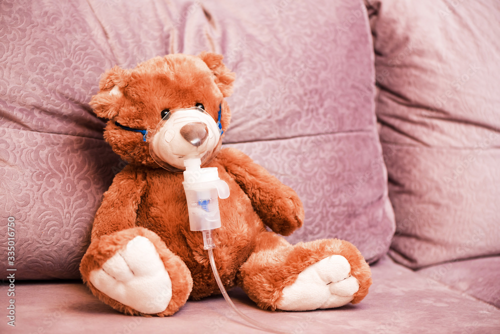 Child makes the procedure to his toy, Teddy Bear with an inhaler ...