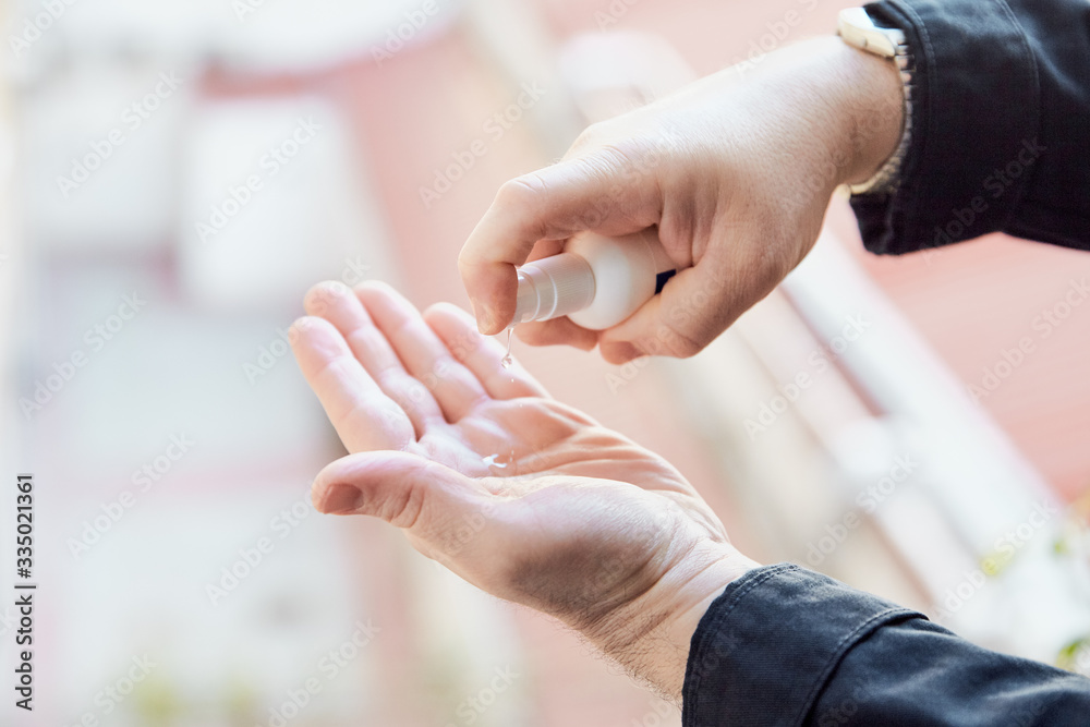 Using sanitizer alcohol hand rub for hands hygiene at home or public ...