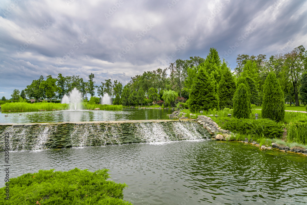 Landscaping. Beautiful pond with fountain in green park at Mezhgorye ...