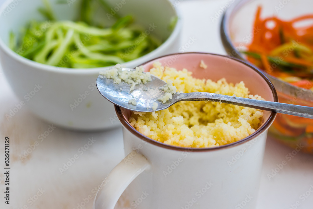 Cooked couscous durum wheat grain porridge in cup. Crushed semolina ...