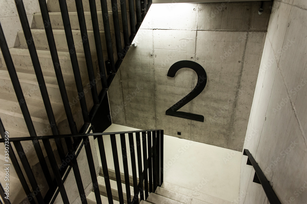 Foto de Huge second floor sign in the staircase. Concrete walls and ...