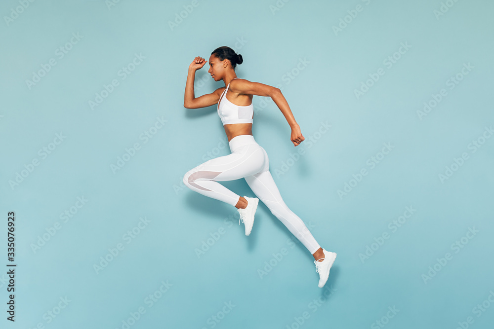 Sports woman running in studio. Full length shot of young female ...