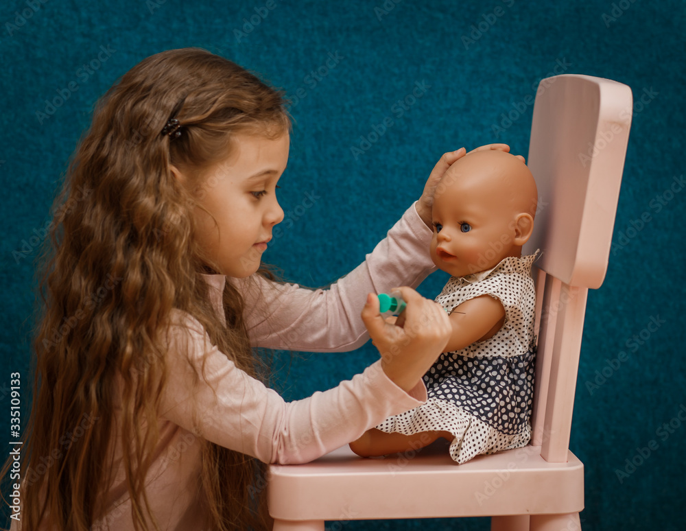 little girl plays doctor, makes an injection to the doll Stock Photo ...