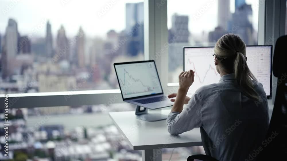 Young female employee checking data analytic while testing trade ...
