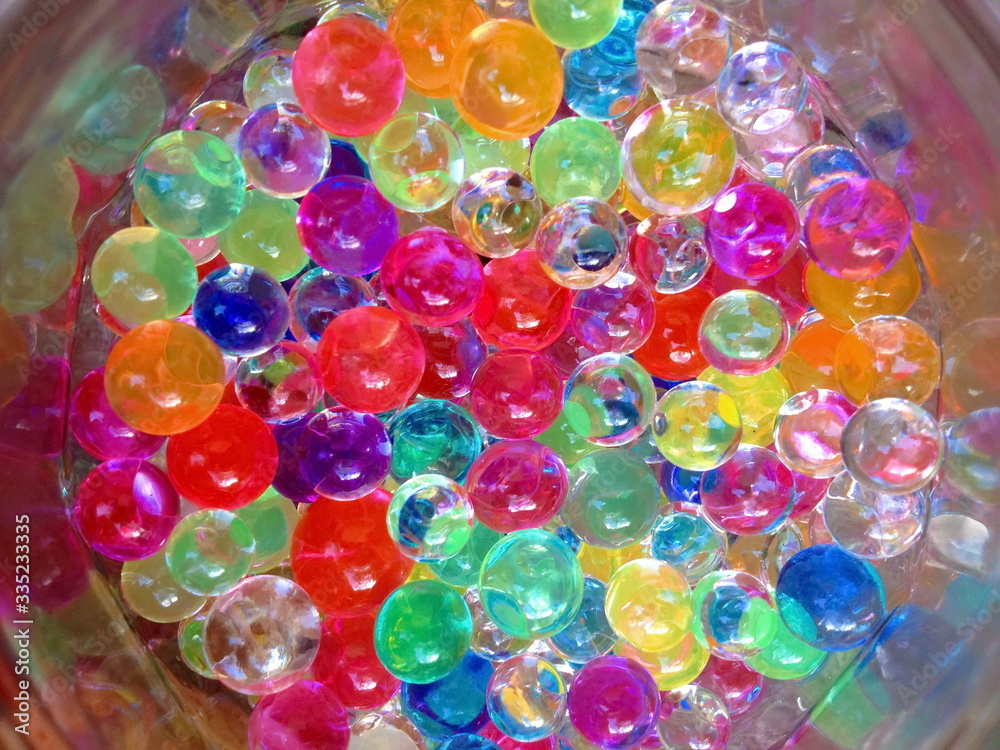 Background with colored Orbeez balls in a transparent container close ...