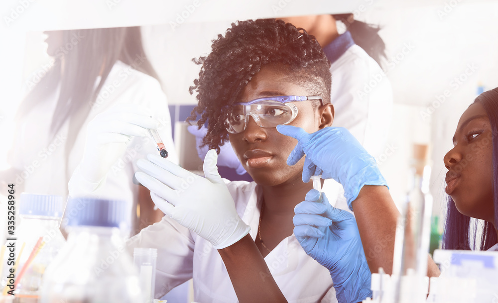 Female African medical students, young graduates in research laboratory ...