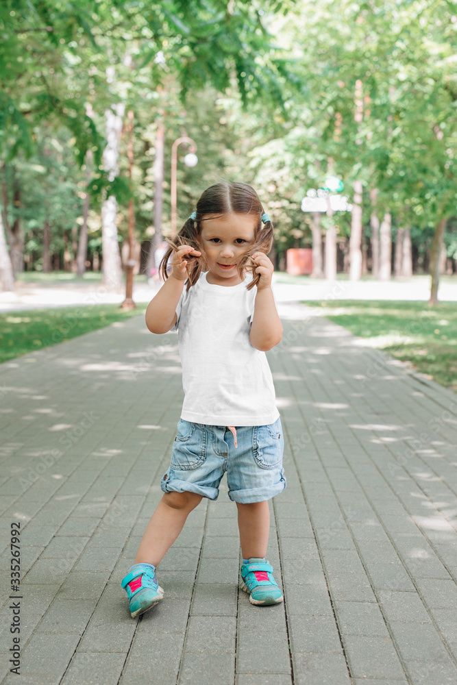 little smiling girl model in white shirt phaving fun in park Stock ...