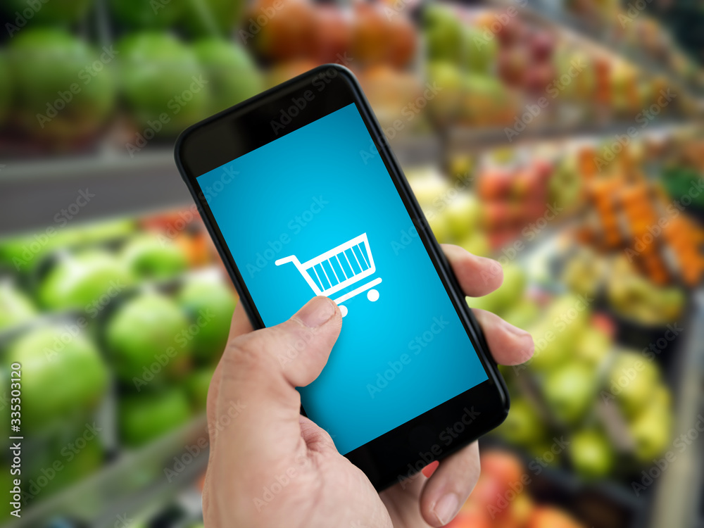 Hand holding mobile phone with grocery online on screen with blur ...