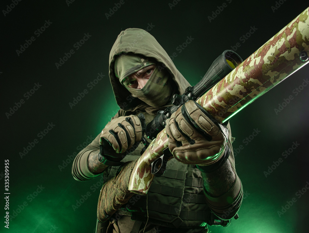 an athletic guy with a tattoo poses with a sniper rifle Stock Photo ...