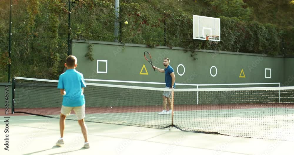 Vidéo Stock Back view of Caucasian teen boy playing big tennis with ...