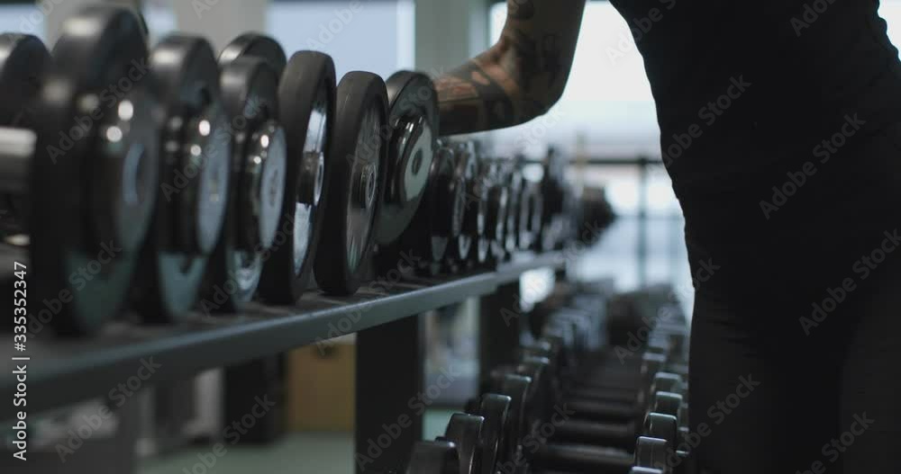 Woman lifting dumbbell weights at gym.Detail of arm lifting weight ...