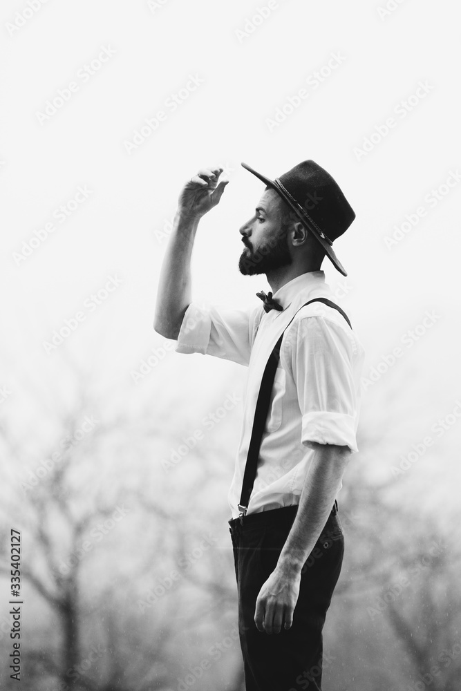 black-and-white portrait of a stylish young man with a beard wearing a ...