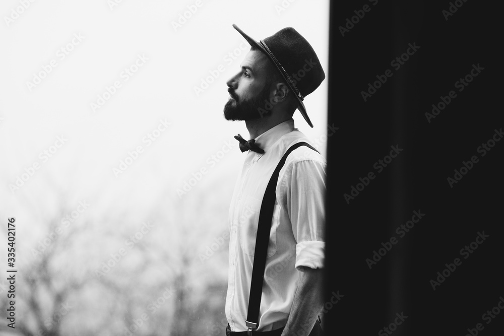 black-and-white portrait of a stylish young man with a beard wearing a ...