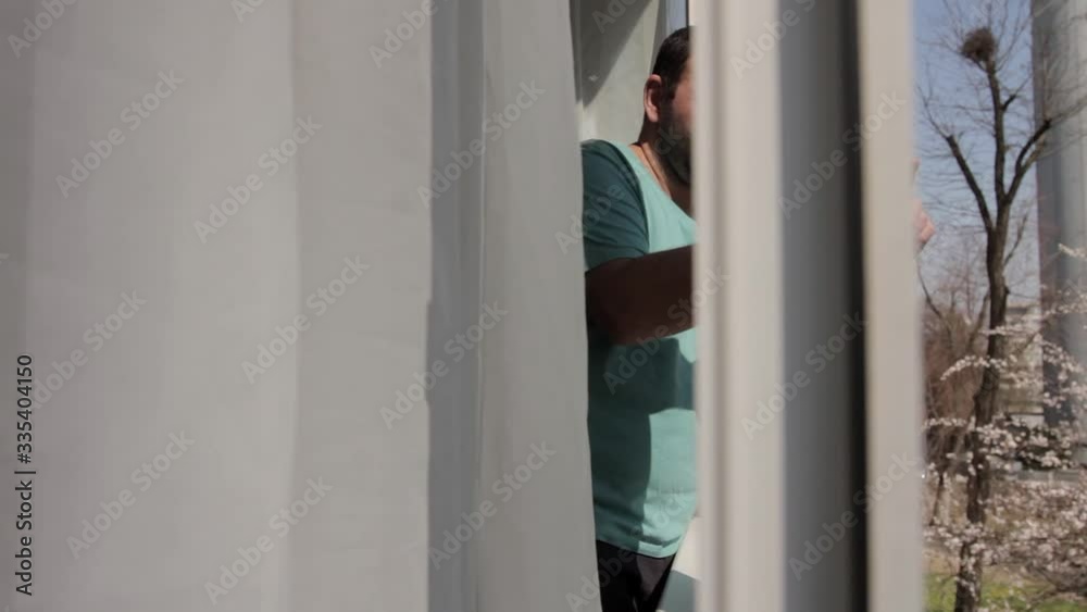 a middle-aged man appears in an open window and shoots video on a ...