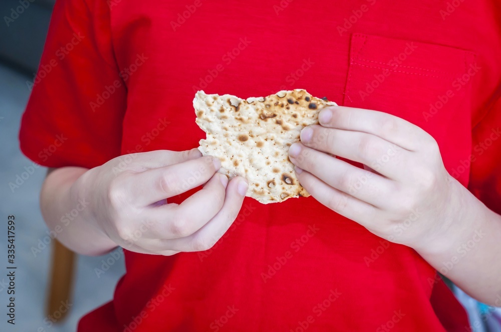 Hands of a Caucasian child holding a piece of traditional Jewish ...