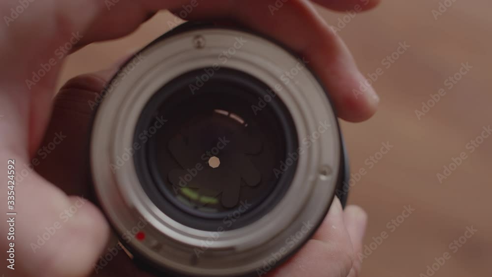 Top view of the photographer's hands checking the lens opening and ...