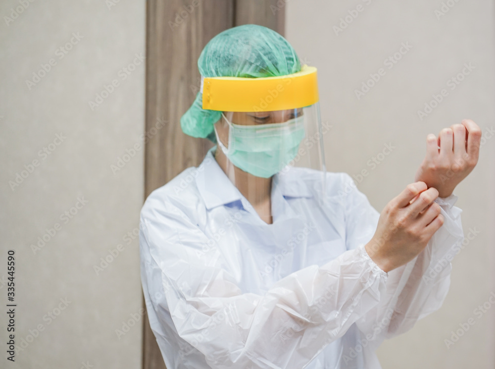 Front-line healthcare workers prepare wearing Personal Protective ...