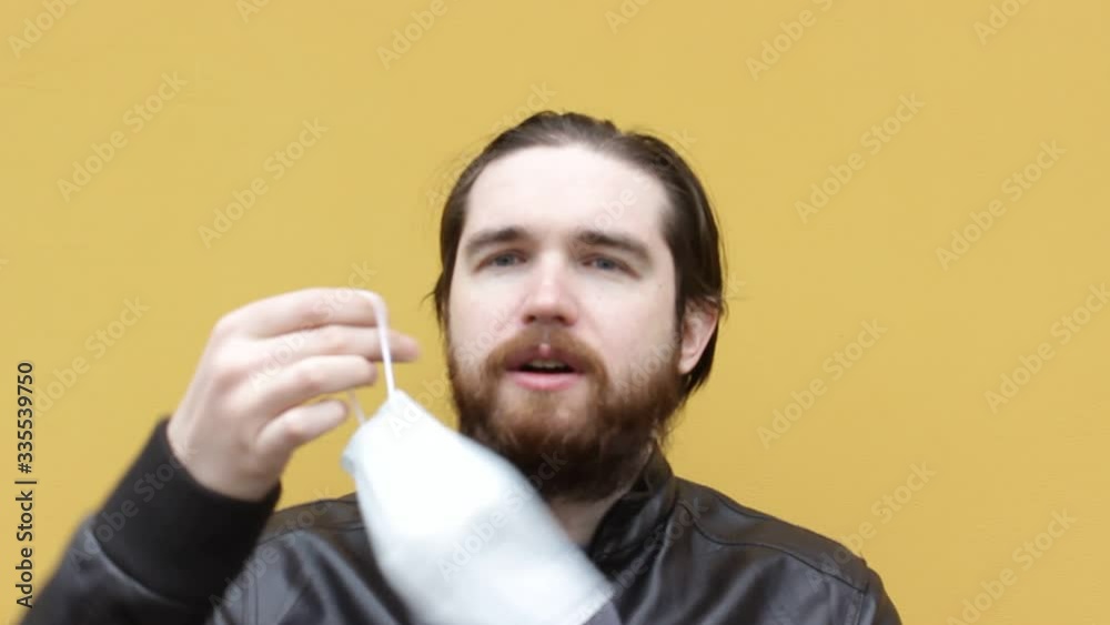 an adult man in a disposable mask sneezes. Instructions on how to wear ...