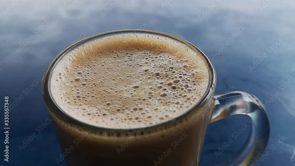 (Teh Tarik) in a transparent cup on a blue table. Tea with milk drinks ...