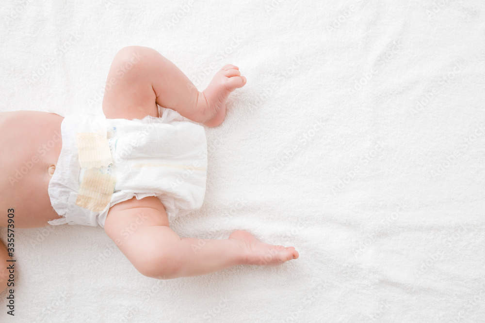 Baby with diaper on white towel. Body part. Closeup. Empty place for ...